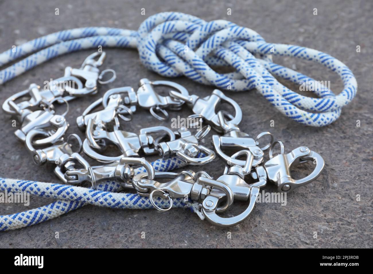 Climbing rope with carabiners on asphalt, closeup Stock Photo - Alamy
