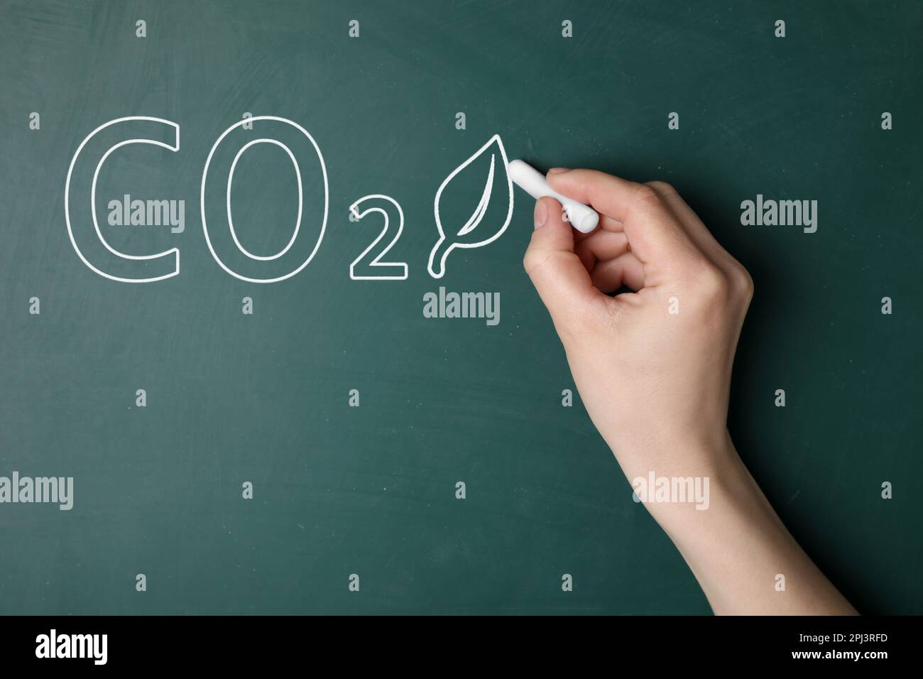 Reduce carbon emissions. Woman drawing leaf and chemical formula CO2 on ...