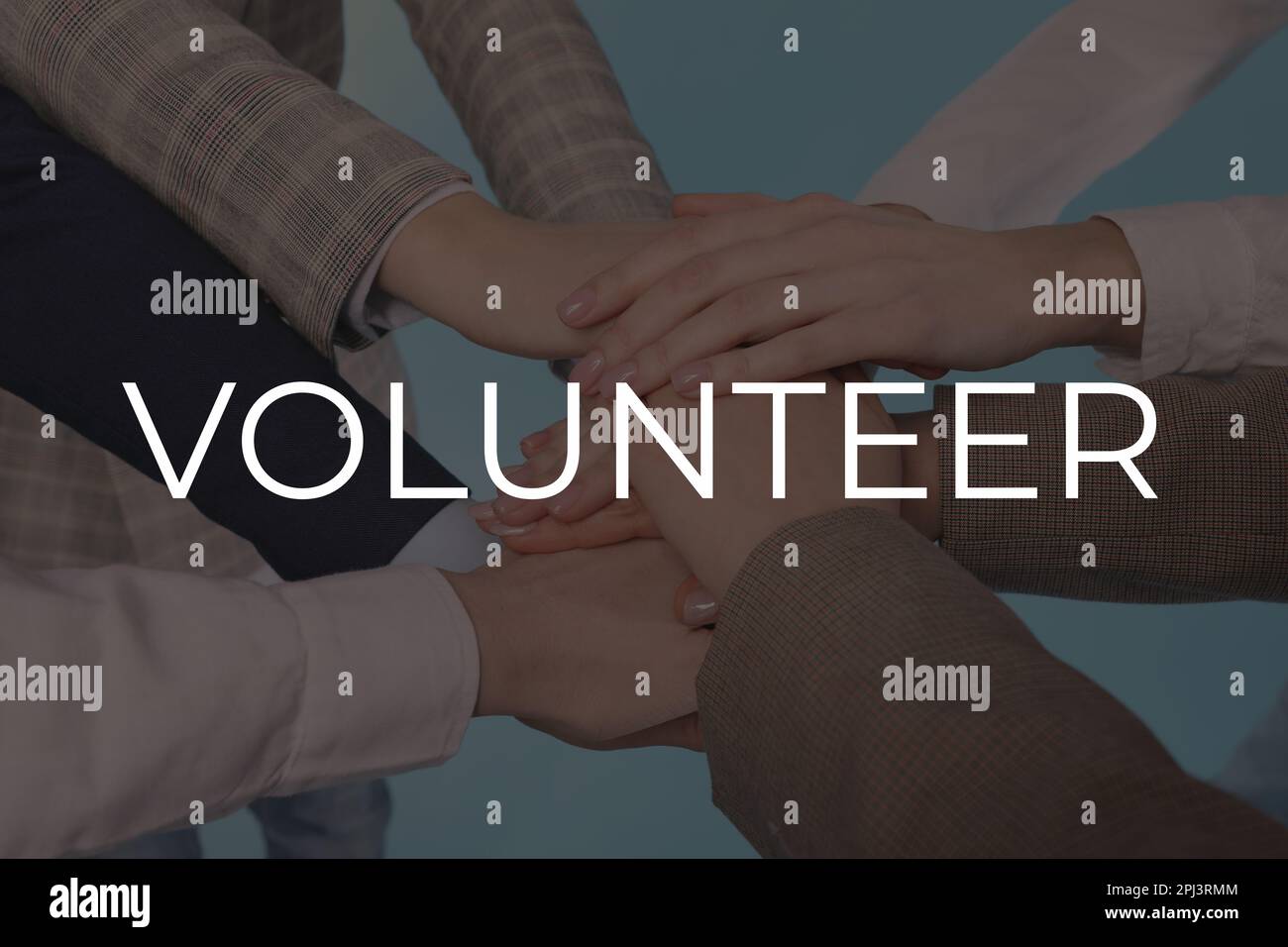 Group of volunteers putting hands together on light background, closeup ...