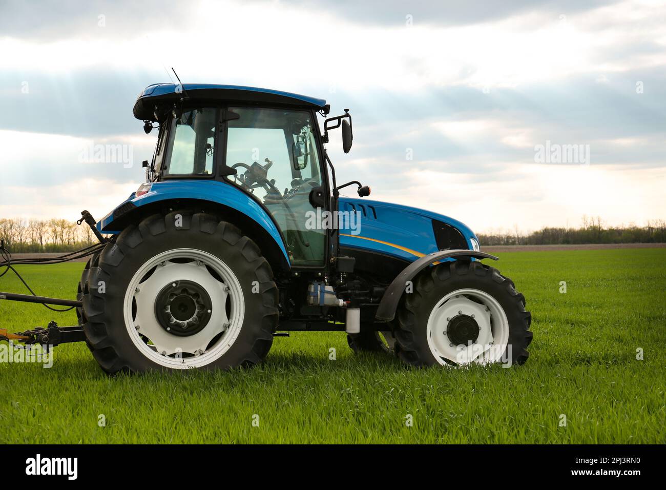 Modern tractor in field on spring day. Agricultural industry Stock ...