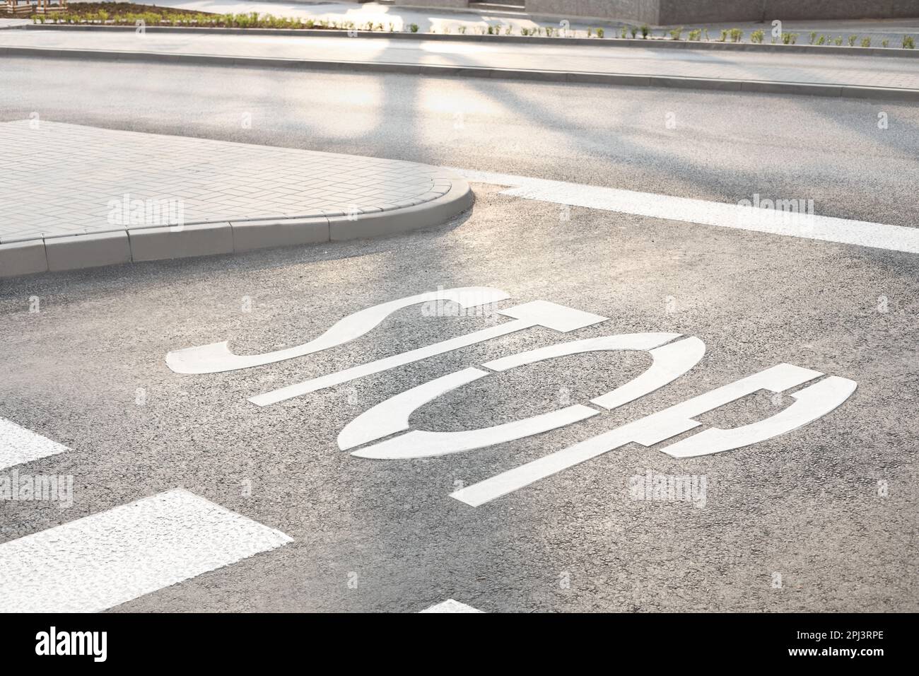White sign STOP written on asphalt road outdoors Stock Photo - Alamy