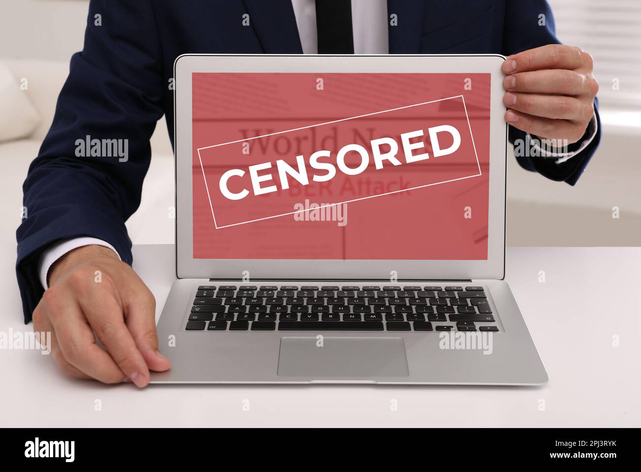 Display with censorship sign. Man with laptop at white table, closeup ...