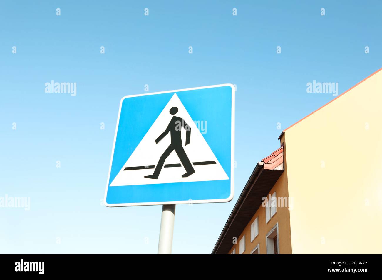 Traffic sign Pedestrian Crossing against blue sky, low angle view Stock ...