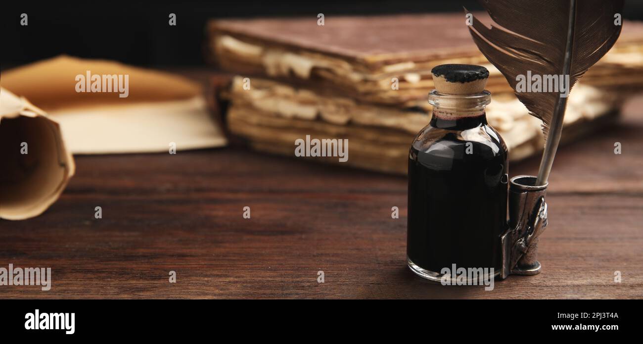 Quill and bottle of ink on wooden table, space for text. Banner design ...