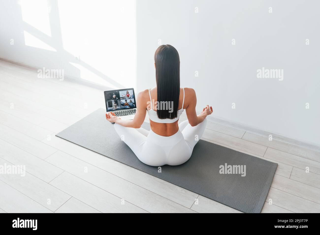 With laptop. Young caucasian woman with slim body shape is indoors at ...