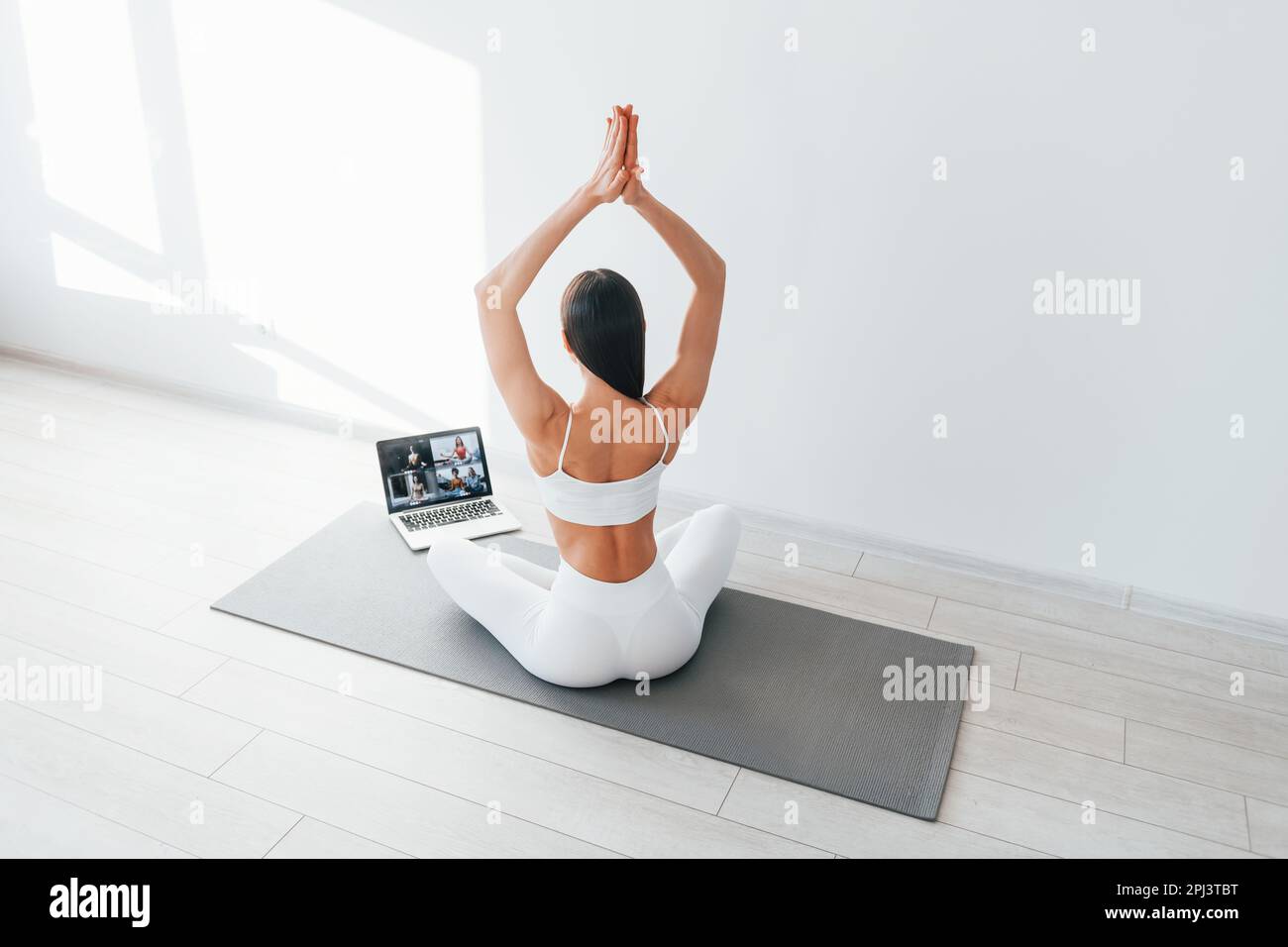 With laptop. Young caucasian woman with slim body shape is indoors at ...