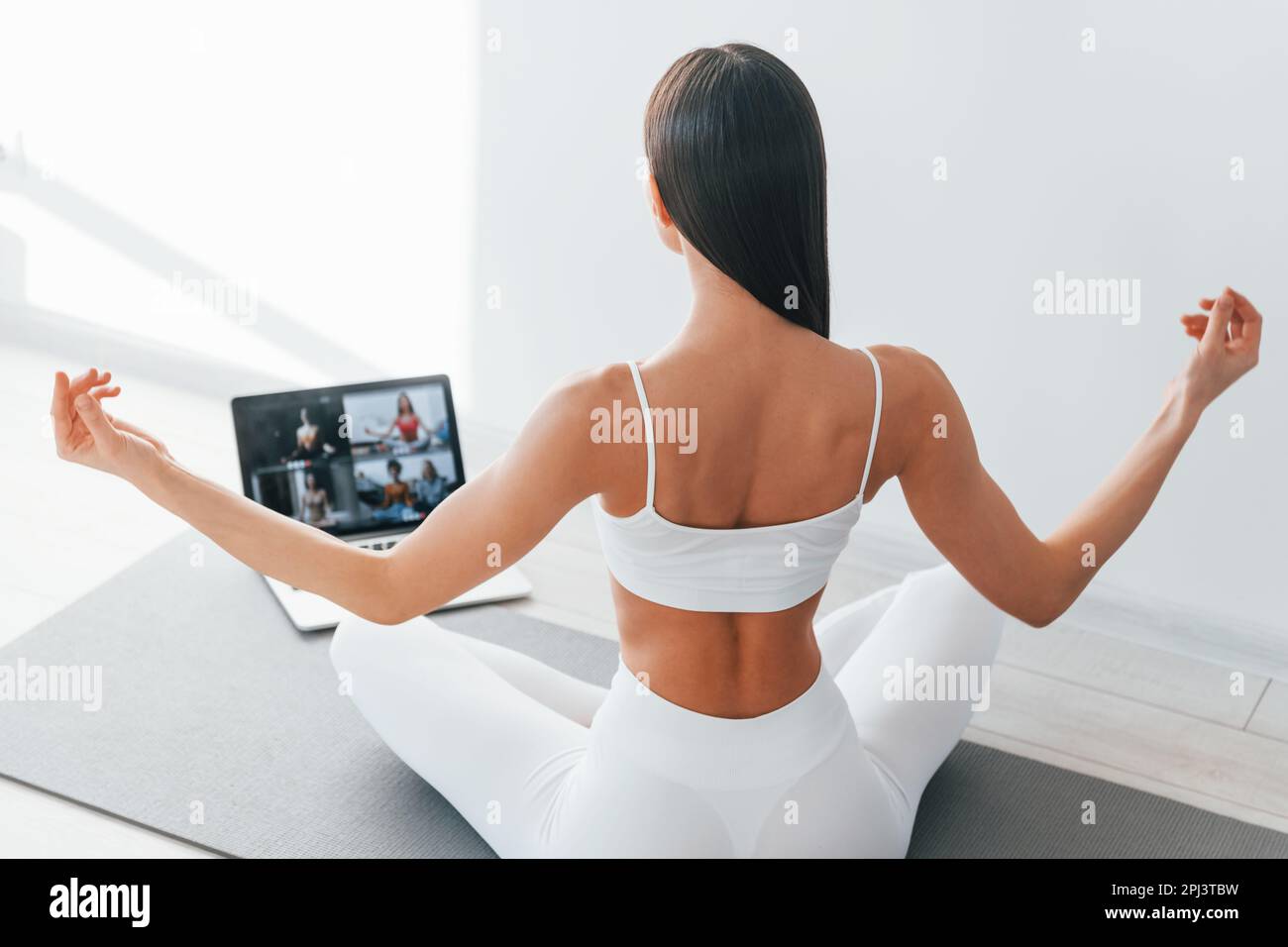 With laptop. Young caucasian woman with slim body shape is indoors at ...