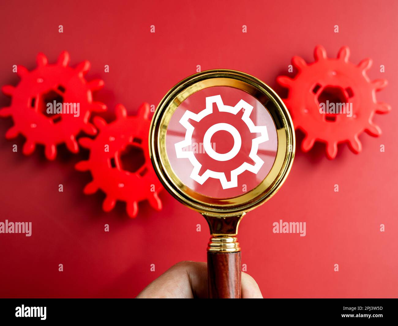 Digital gear wheel symbol appear on magnifying glass lens in ...