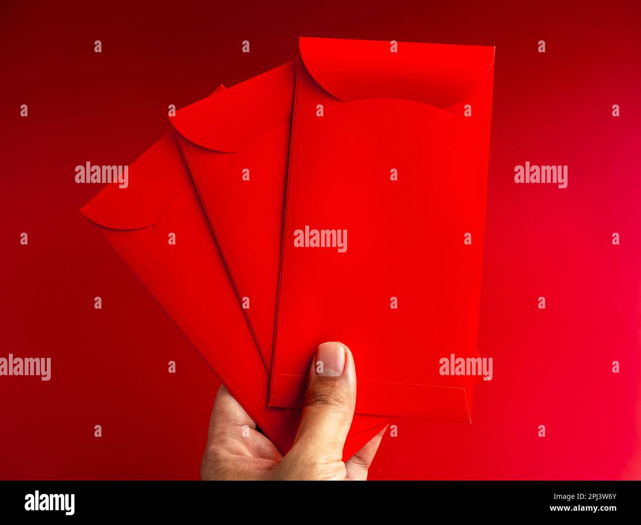 Three red envelope holding by hand isolated on red background. 3 ...