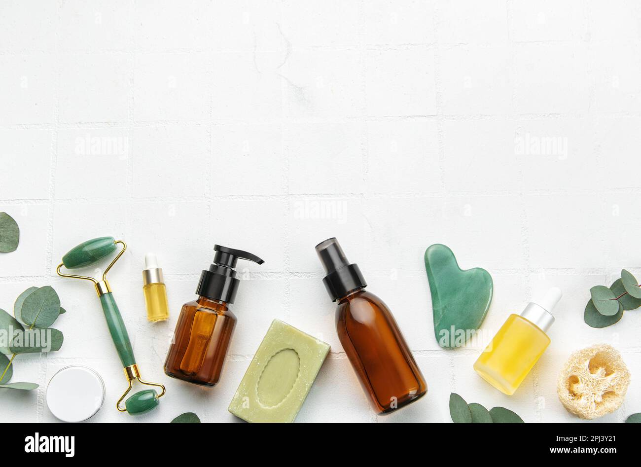 Soap, eucalyptus, aroma oil, spa objects on white tile background. Top ...