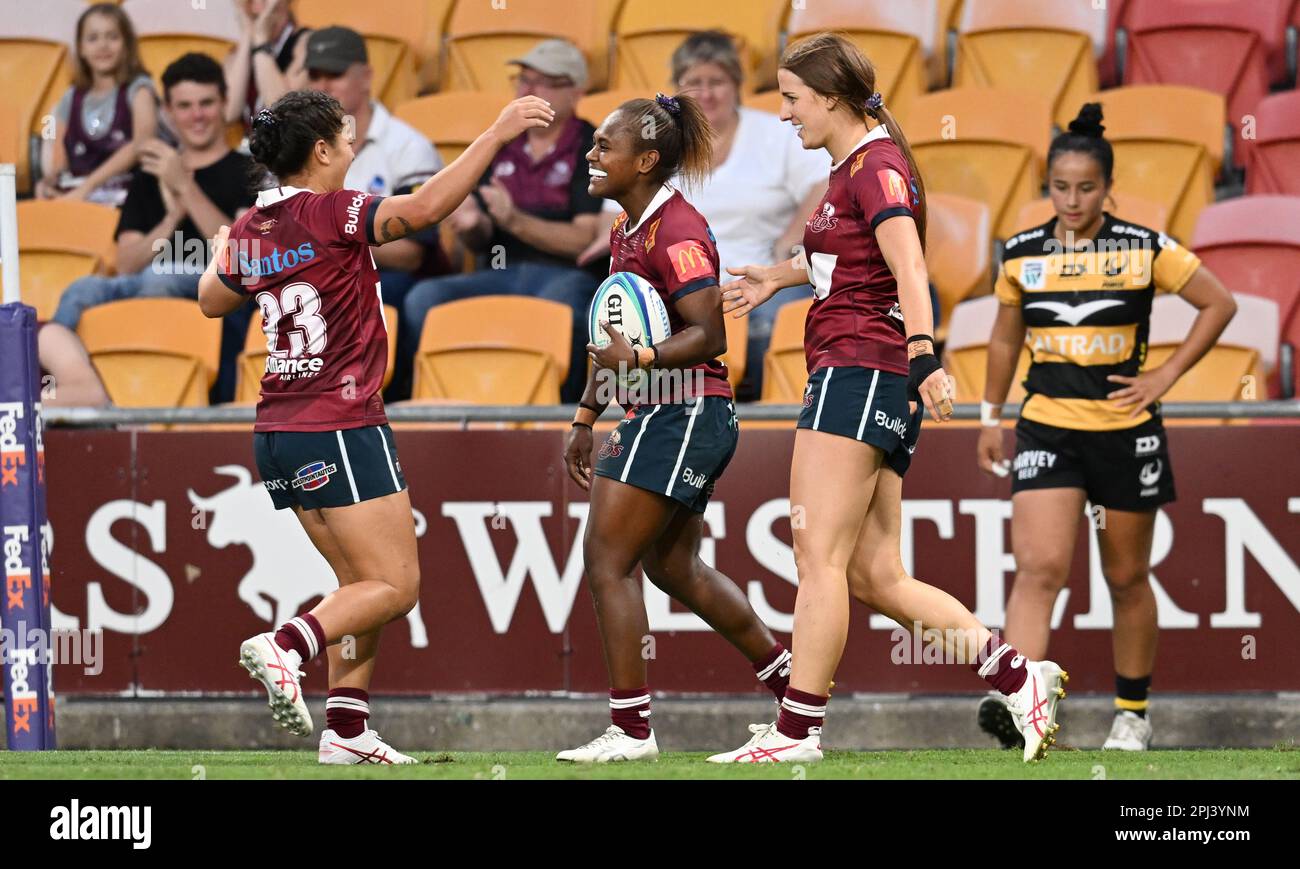 Ivania Wong (centre) of the Reds celebrates scoring a try with team ...