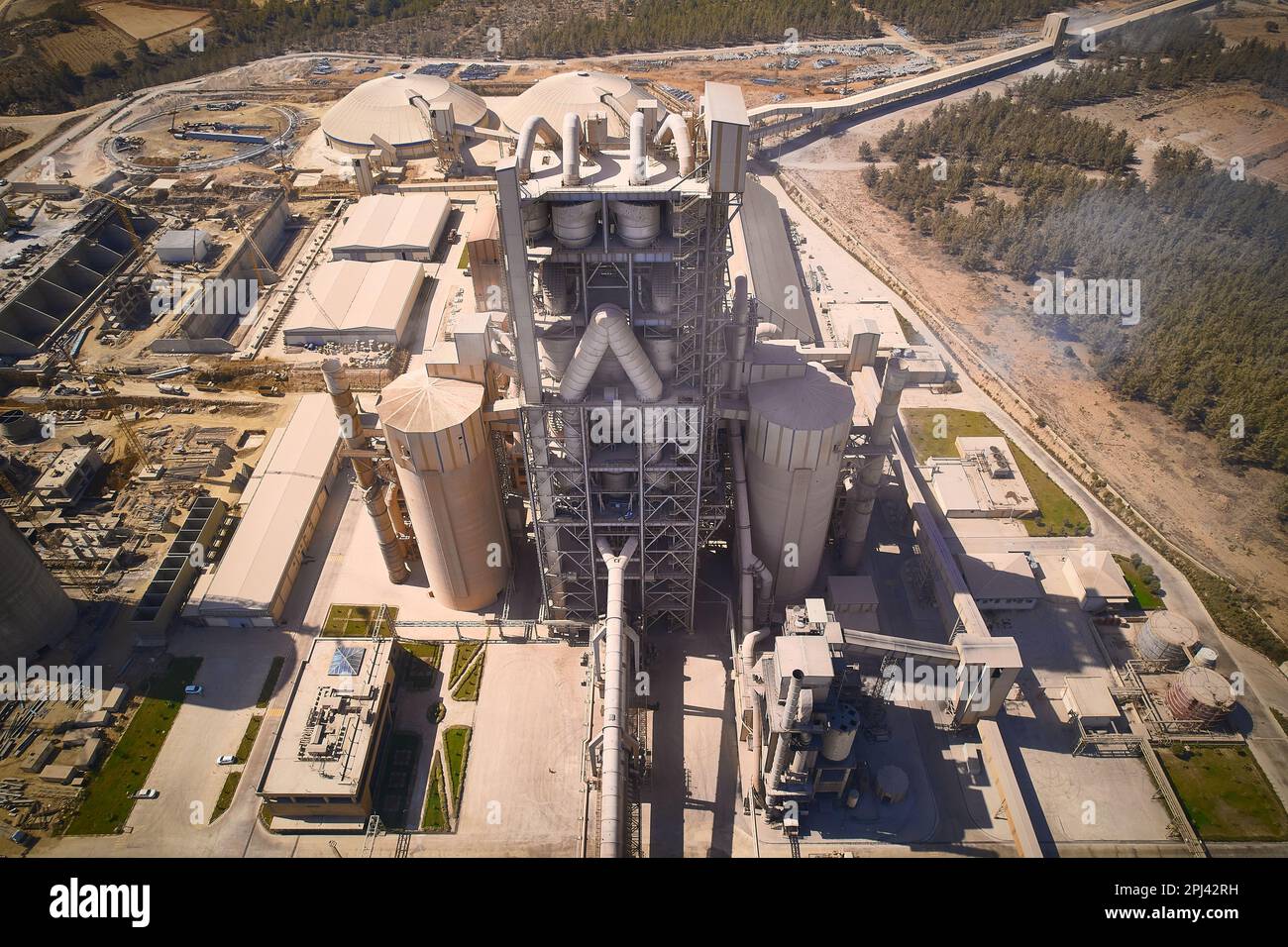 Huge cement producing plant. Aerial view of silos towers, pipes and ...