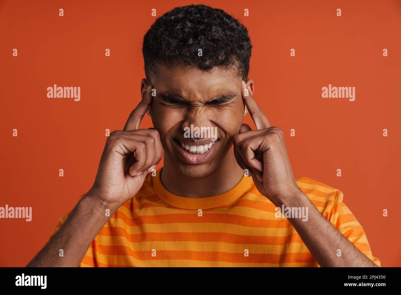 Young handsome tense african man with closed eyes and clenched teeth ...