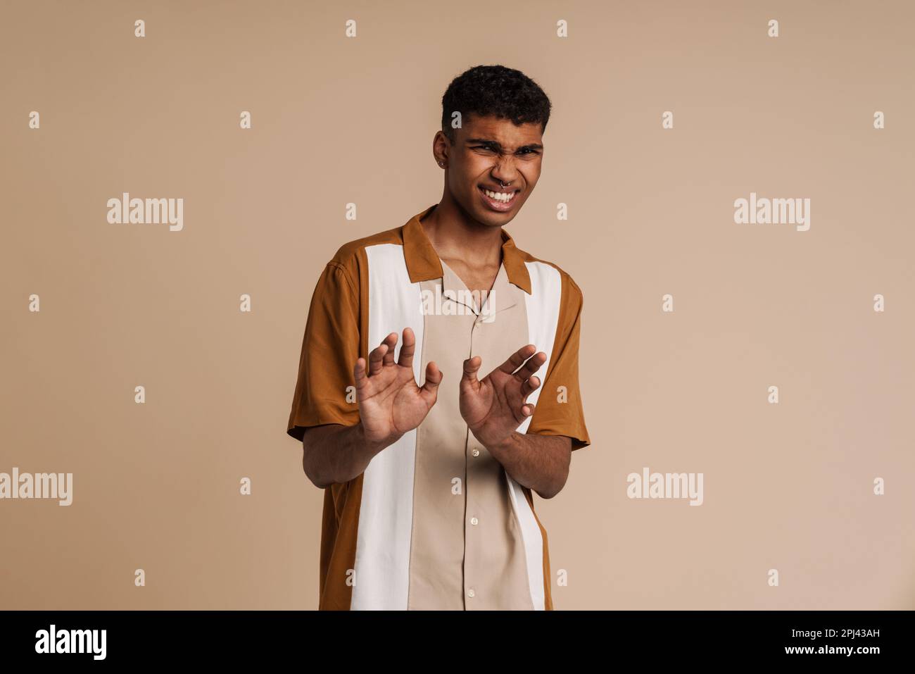 Young african man expressing disgust doing rejection gesture with palms ...