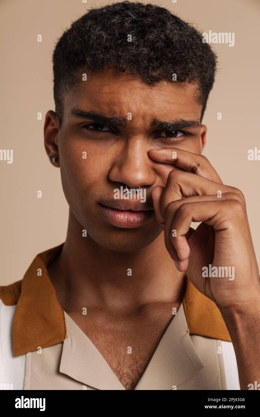 Portrait of young handsome crying african man with piercing looking at ...