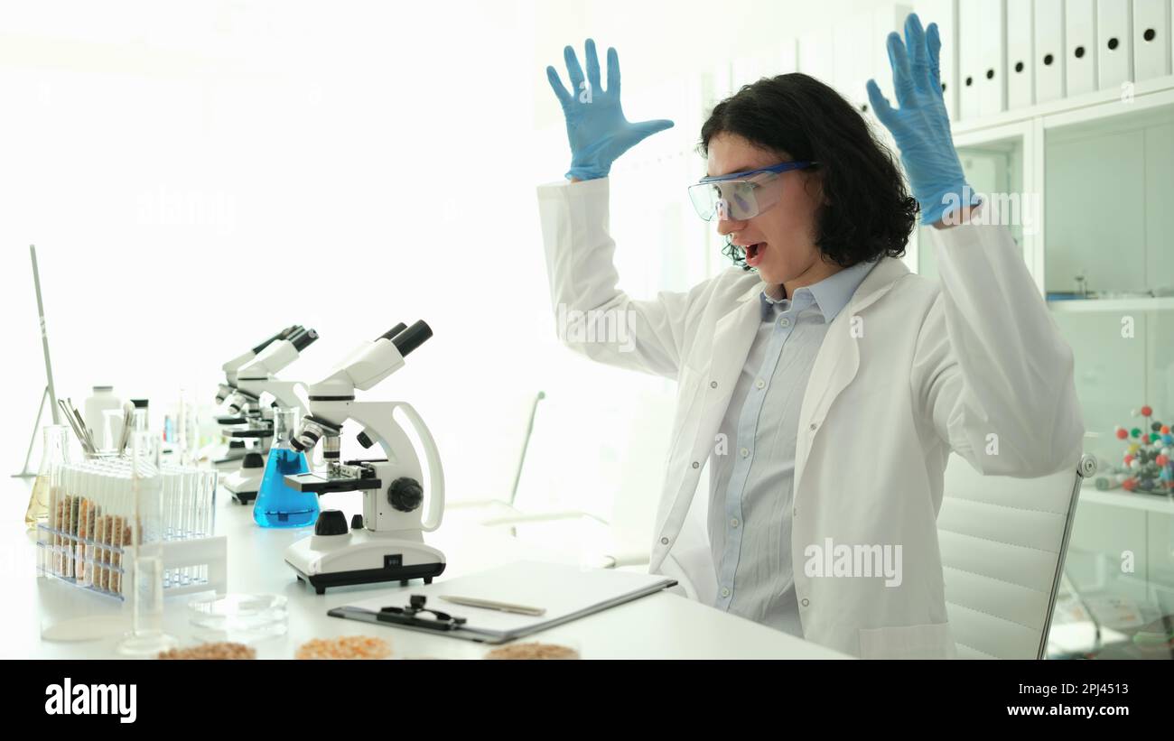 Scientist chemist rejoicing and raising hands up because of new ...