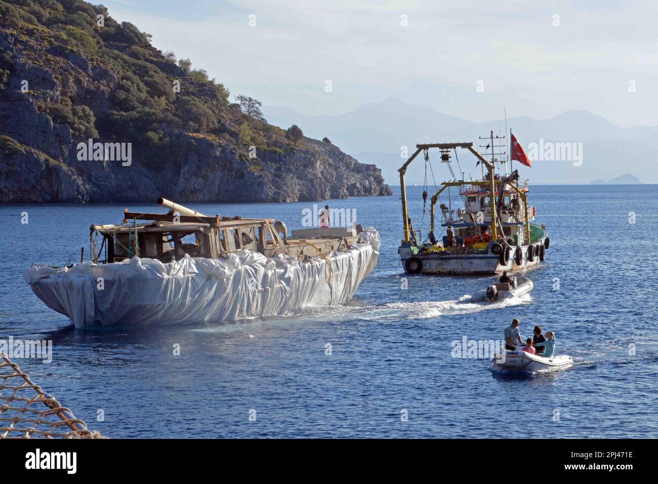 Turkey, Lycia: salvage vessel towing away a wrecked boat made seaworthy ...