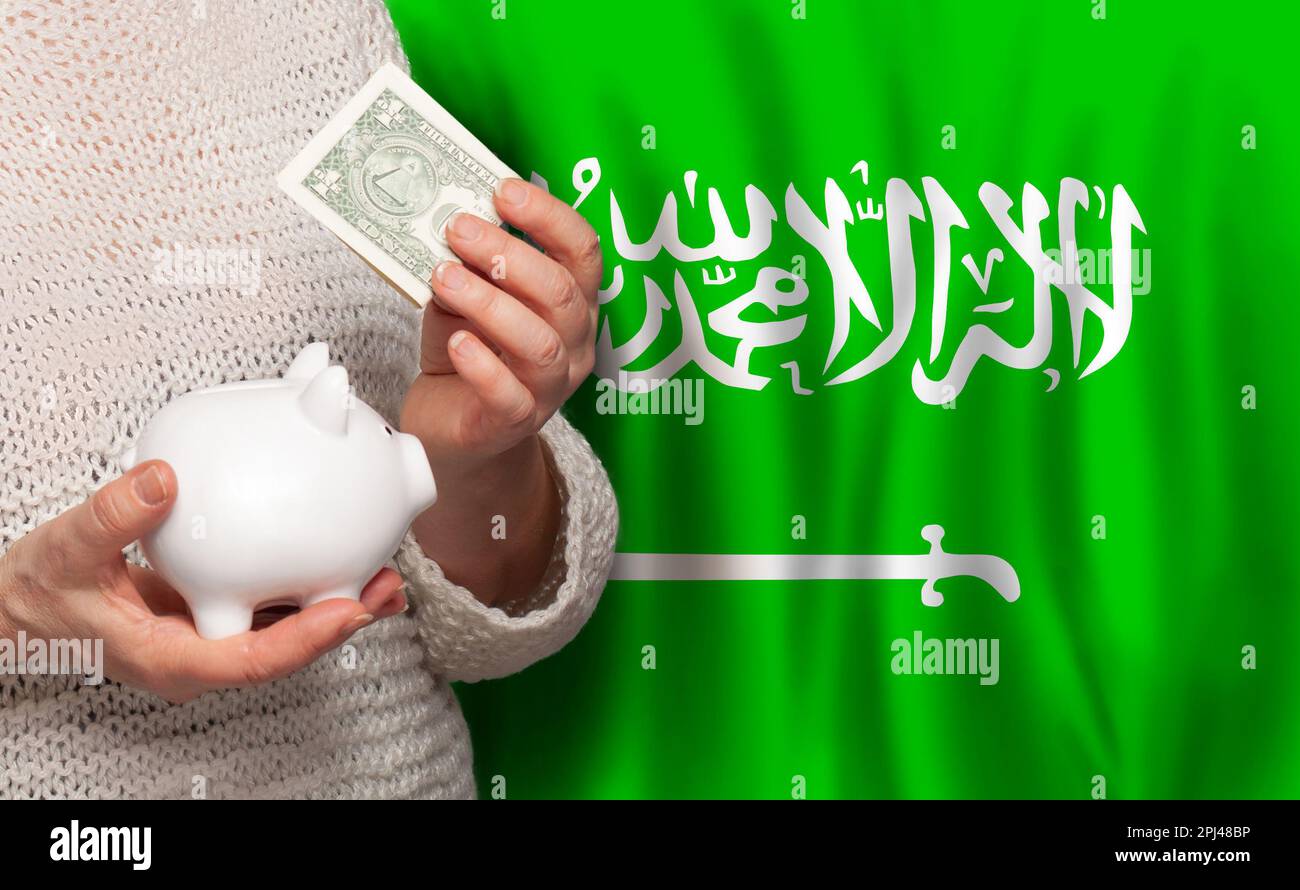 Saudi Arabian woman with money bank on the background of Saudi Arabia ...