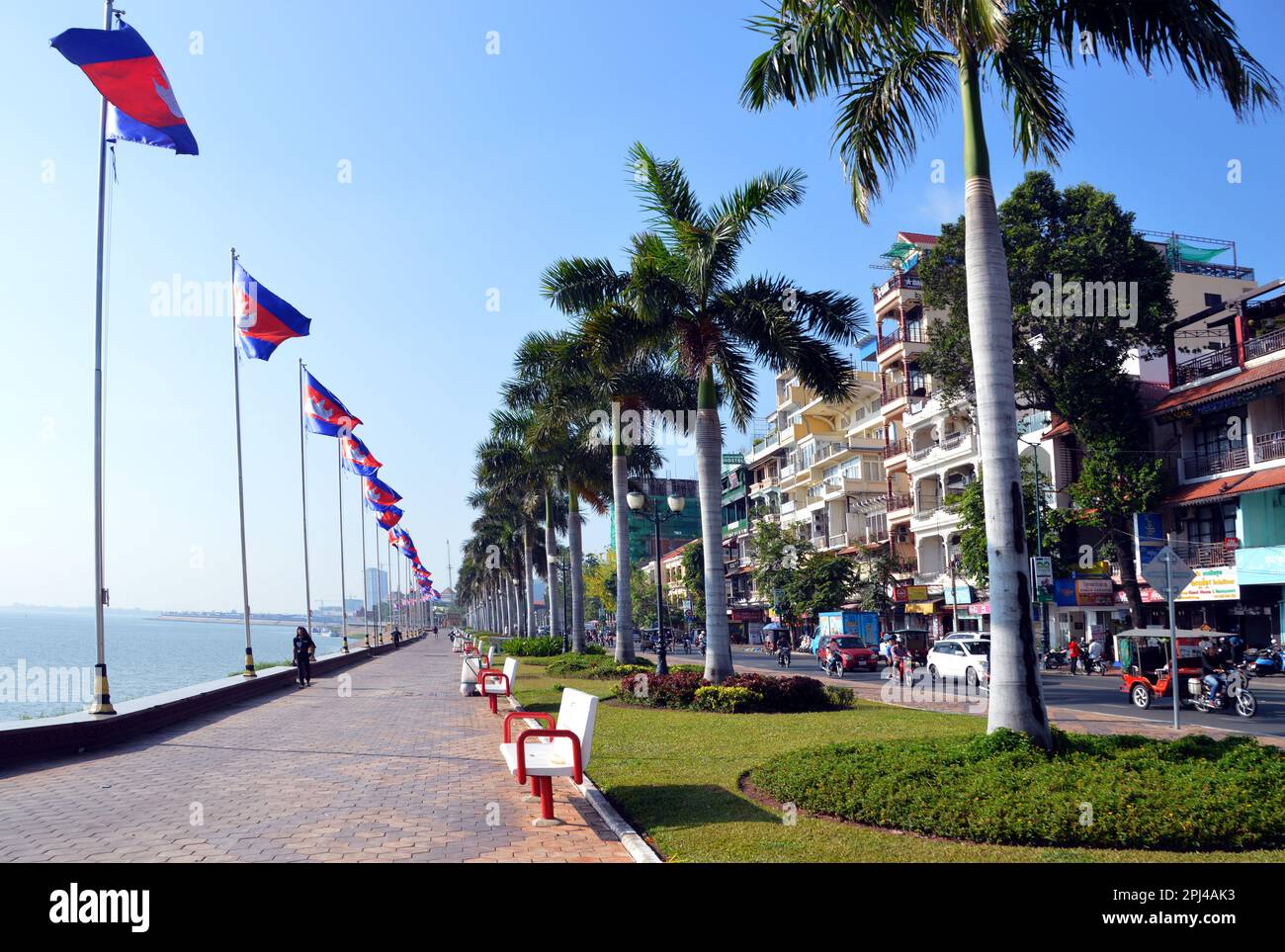 Cambodia, Phnom Penh: riverfront promenade with palm trees and flags ...