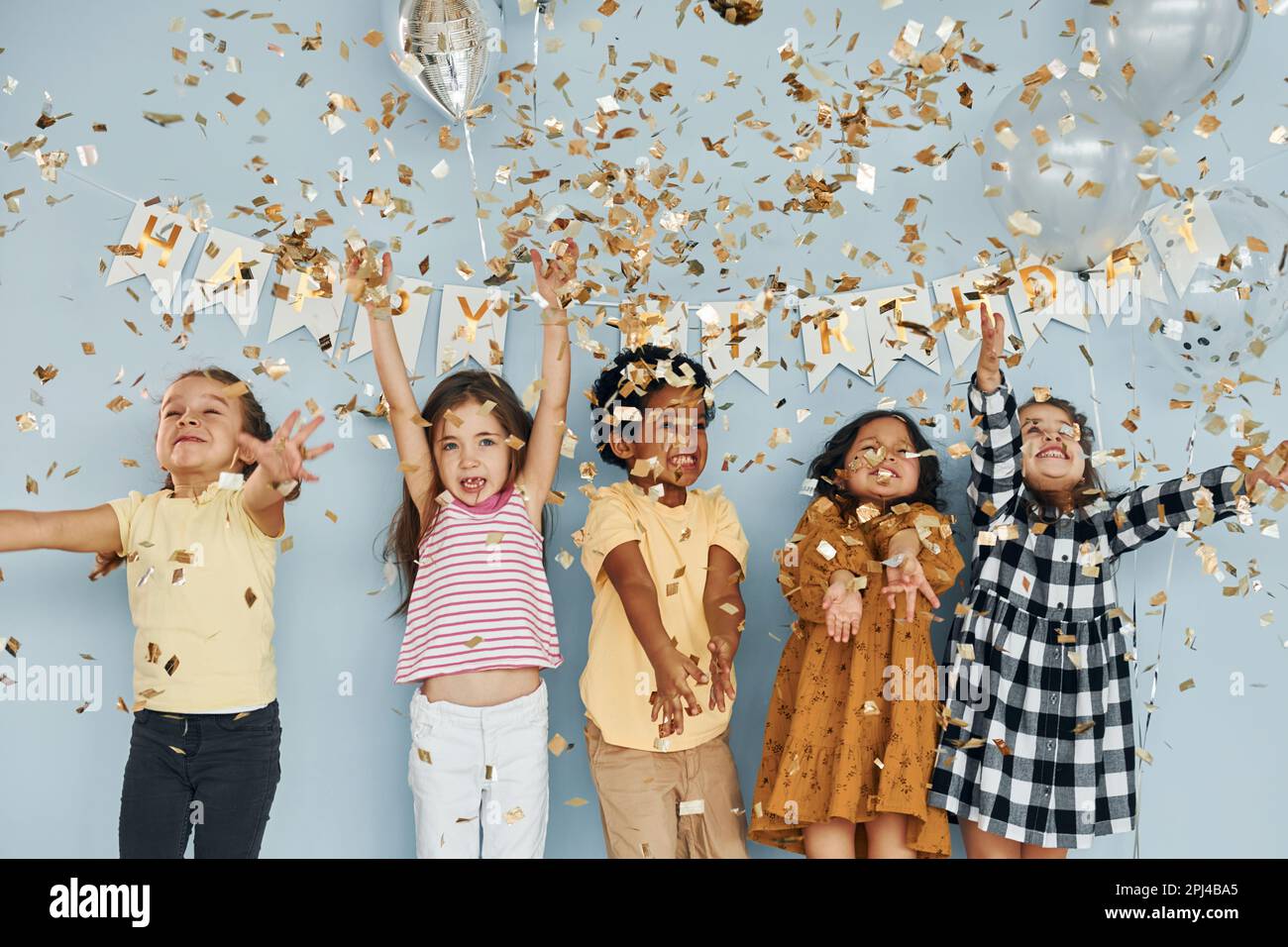 Balloons and confetti. Children on celebrating birthday party indoors ...
