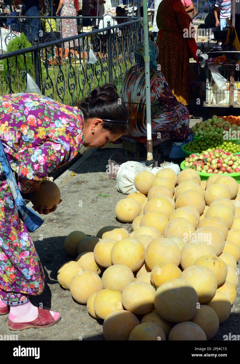 Uzbekistan, Samarkand: choosing a melon in the bazaar Stock Photo - Alamy