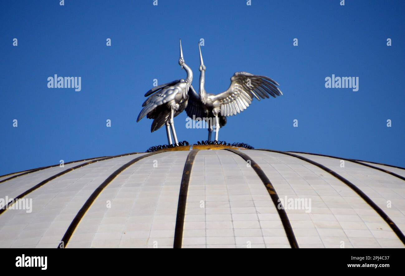 Uzbekistan, Tashkent: figures of a pair of mating storks crown the dome ...