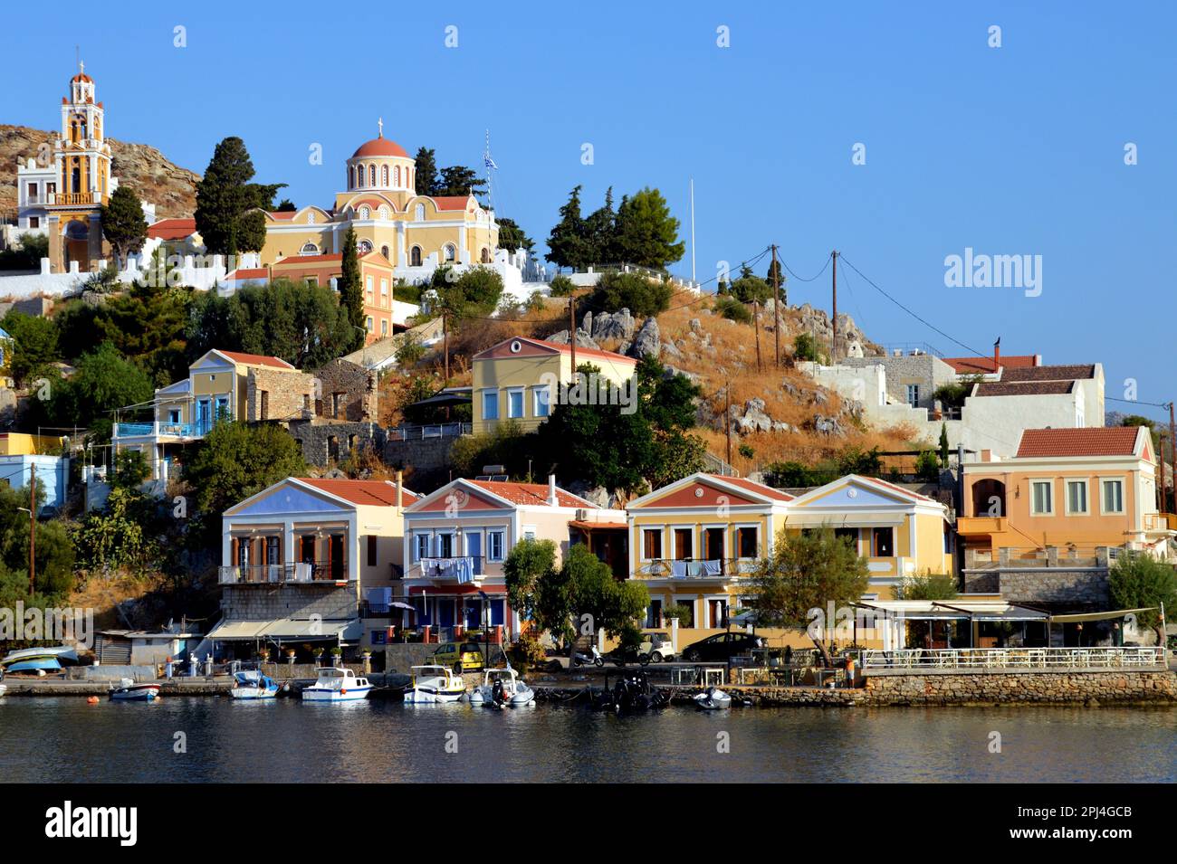 Greece, Island of Symi, Gialos: departing view of two churches on the ...