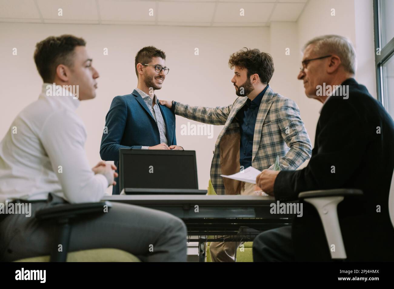 Four businessmen sharing their ideas and discussing about their ...