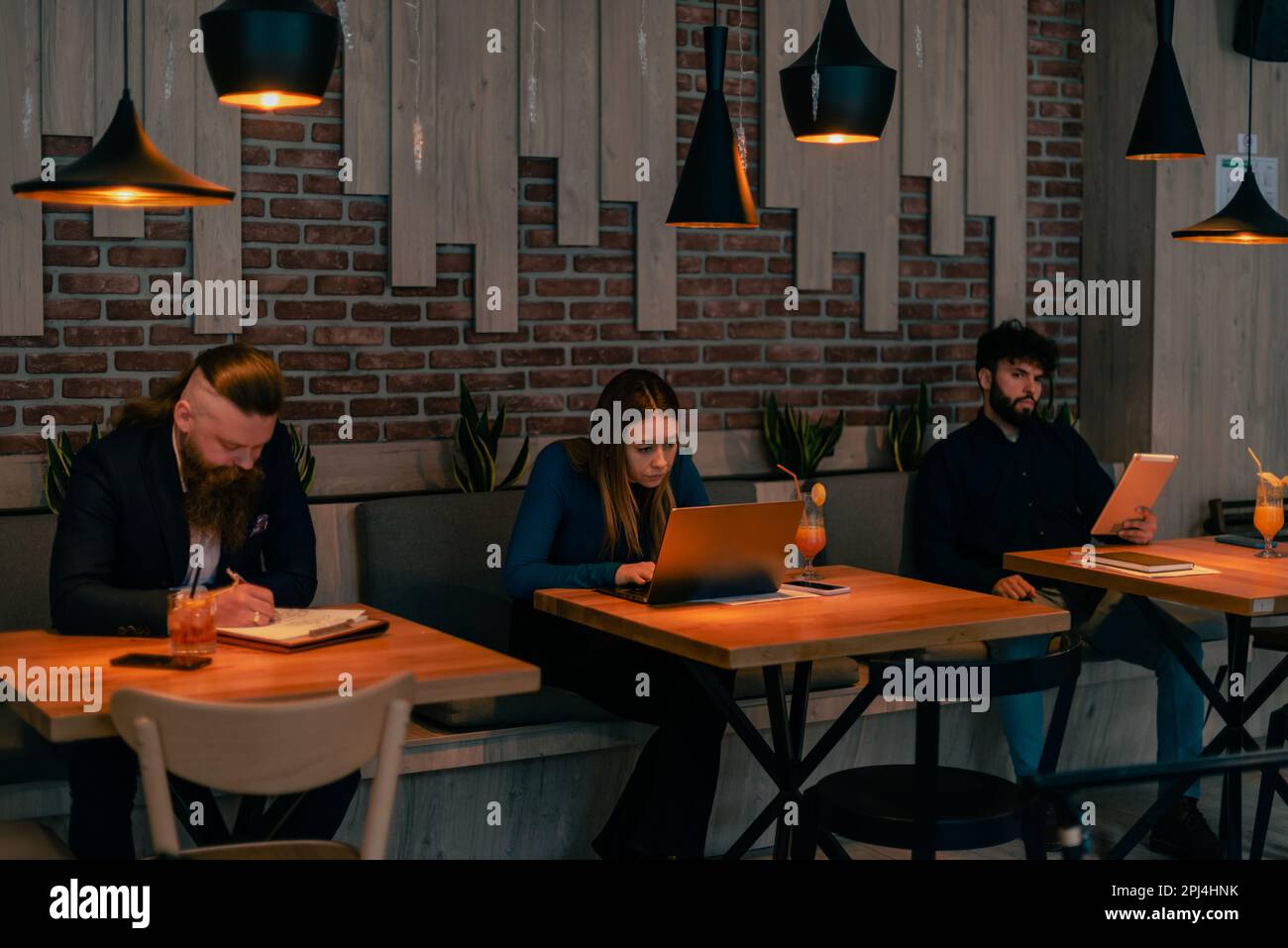 Beautiful successful businesspeople working remotely at the coffee bar ...