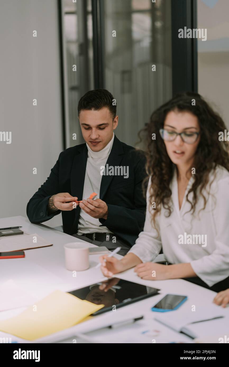 Gorgeous female person is about to write something down. His male ...