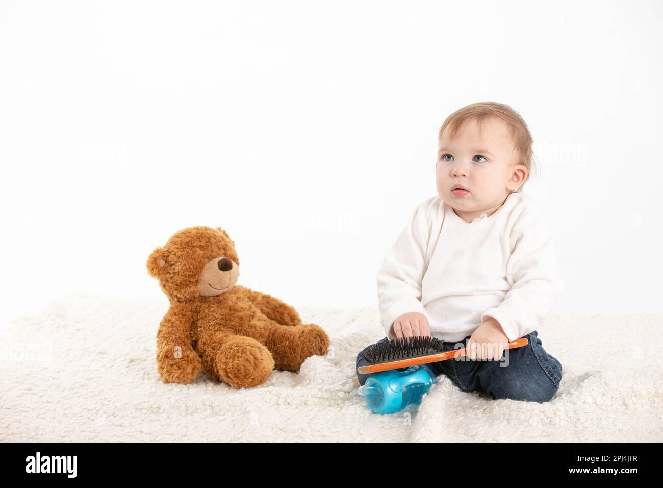 Stock studio photo with a white background of a baby combing his hair ...