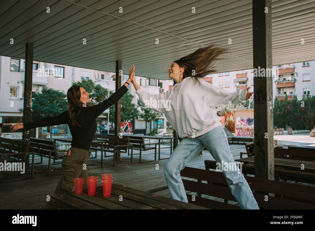 Two best friends high fiving while standing Stock Photo - Alamy
