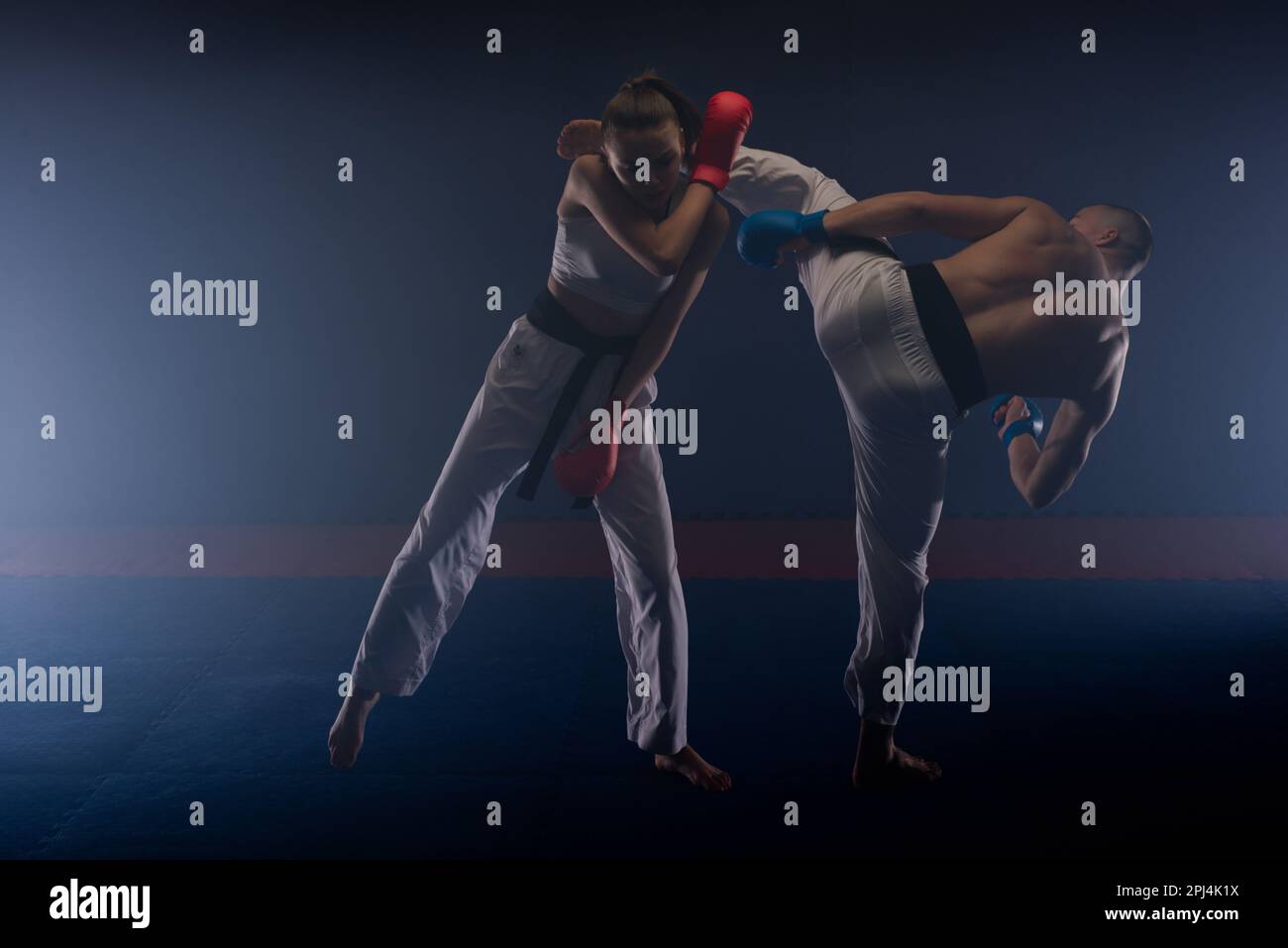 Silhouette of a two young karate friends doing the Ura Mawashi Geri ...