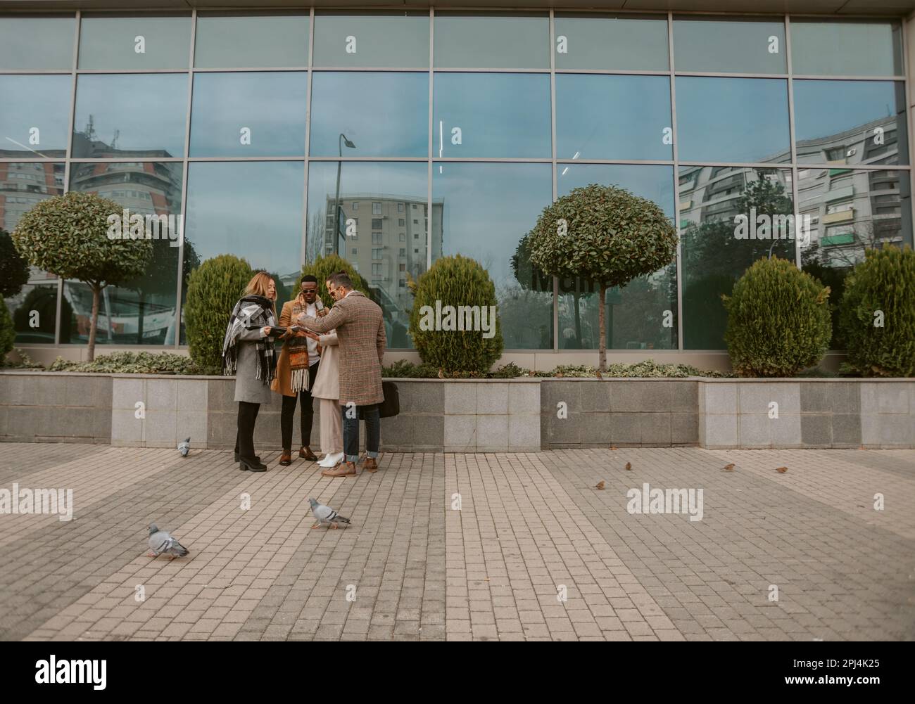 Four business people working while standing in front of the mall Stock ...