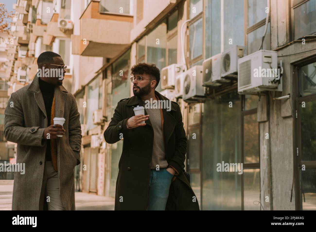 Stylish multiracial business people walking and having a conversation ...