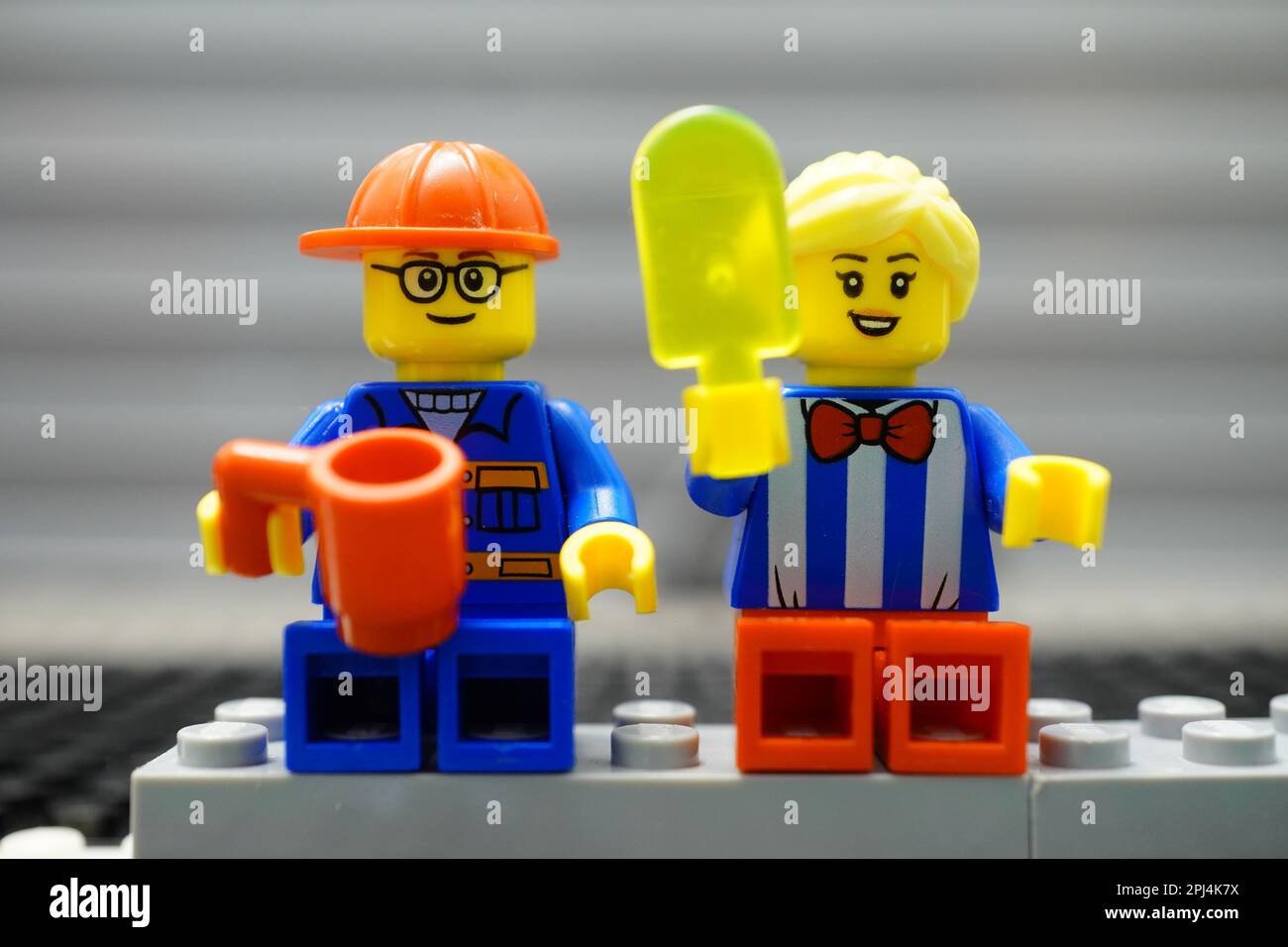 A Lego construction worker and saleswoman having a break while eating ...