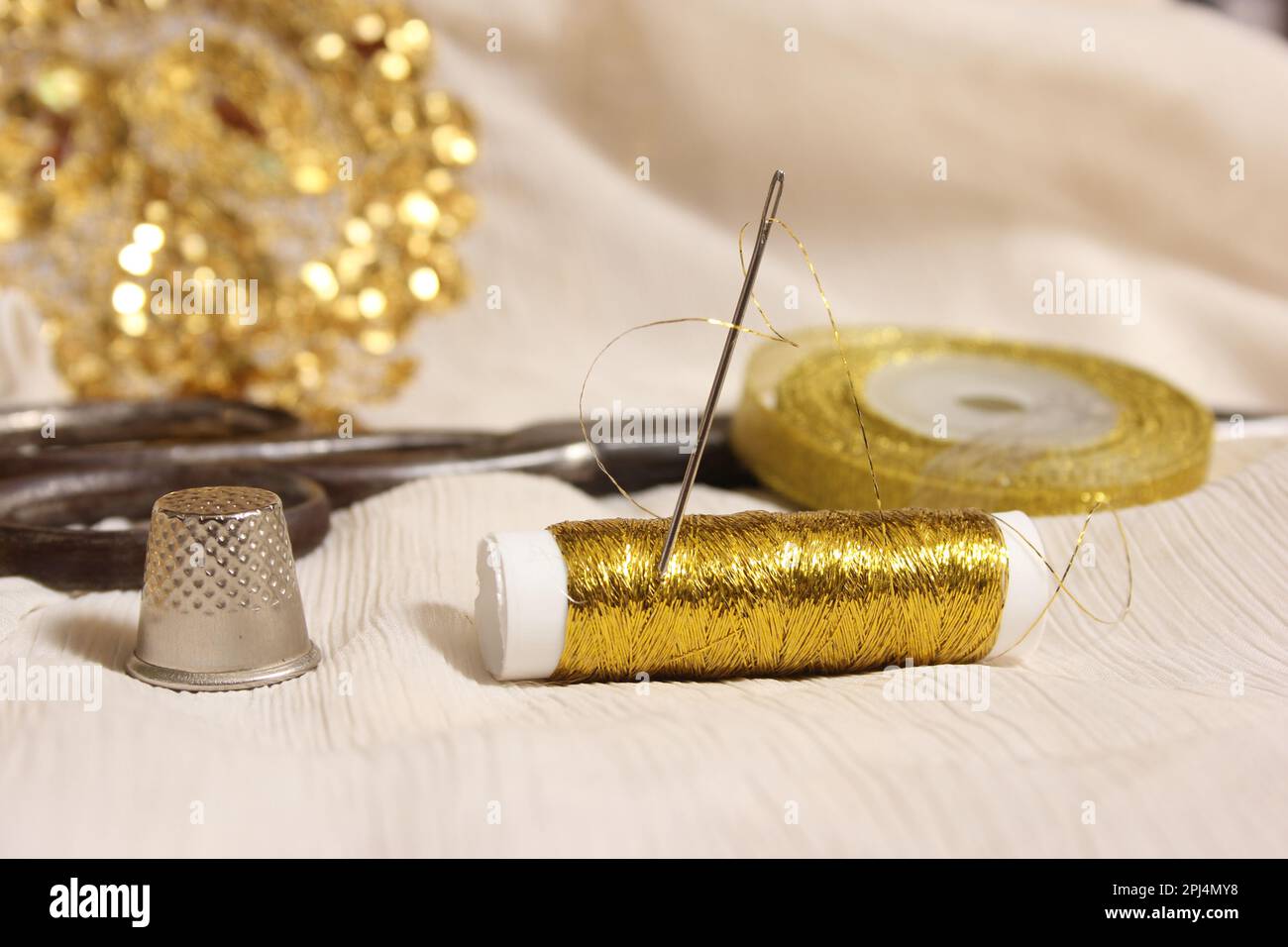 Spool of Gold Metallic Thread and Scissors With Thimble on Off White ...