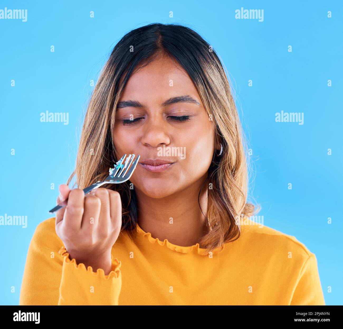 Woman, fork and cake in studio for eating dessert, satisfied or eyes ...