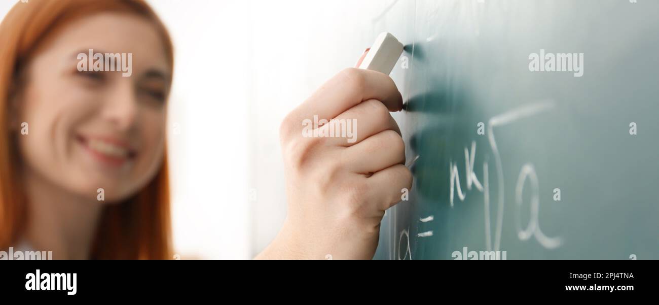 Teacher writing on chalkboard in classroom, closeup. Banner design ...