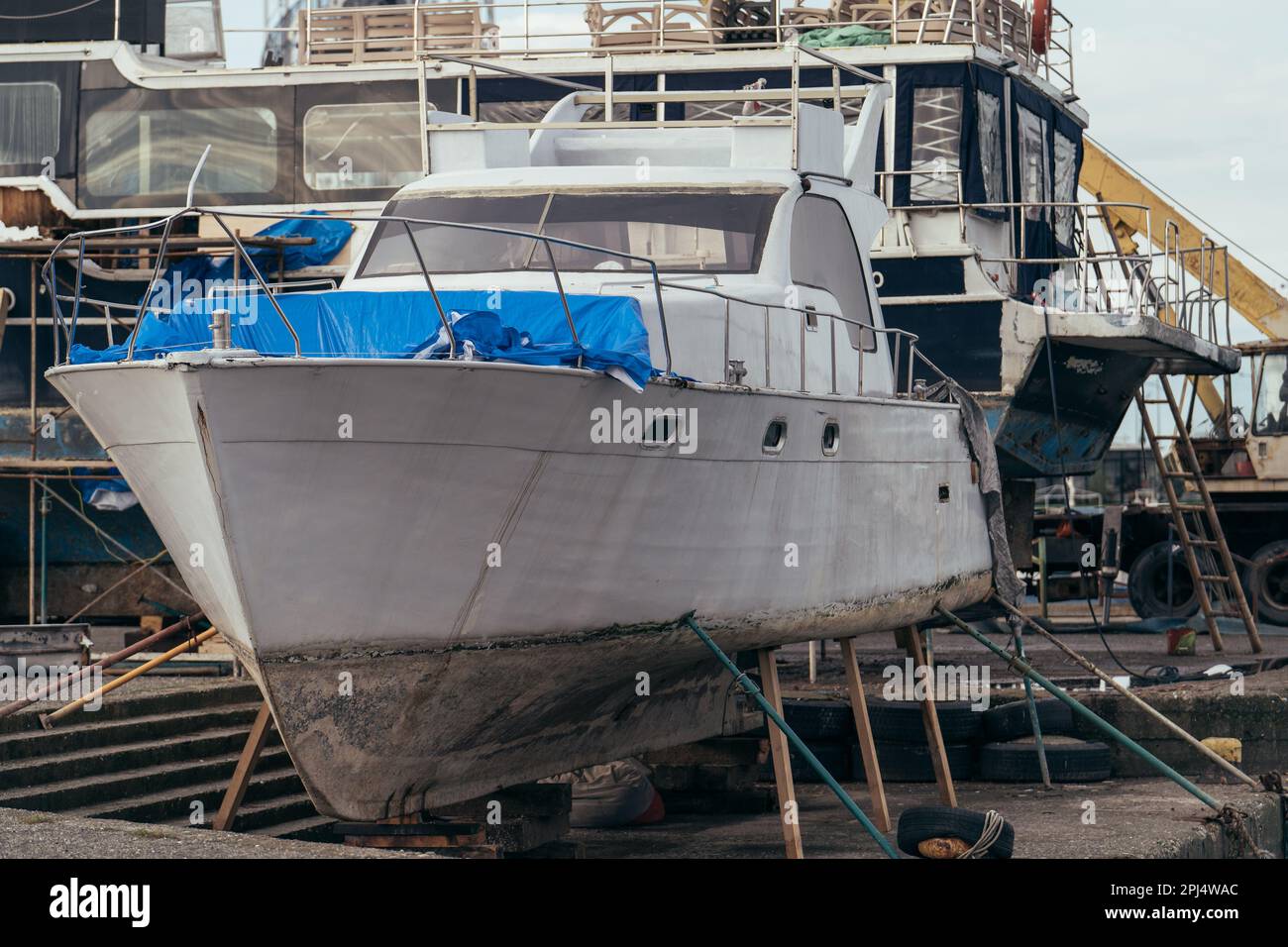 Marine sea boat under repair and maintenance on pier Stock Photo - Alamy
