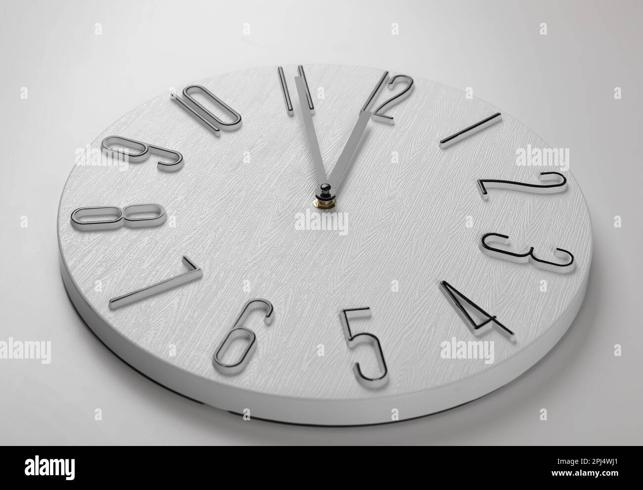 Stylish analog clock hanging on white wall. New Year countdown Stock ...