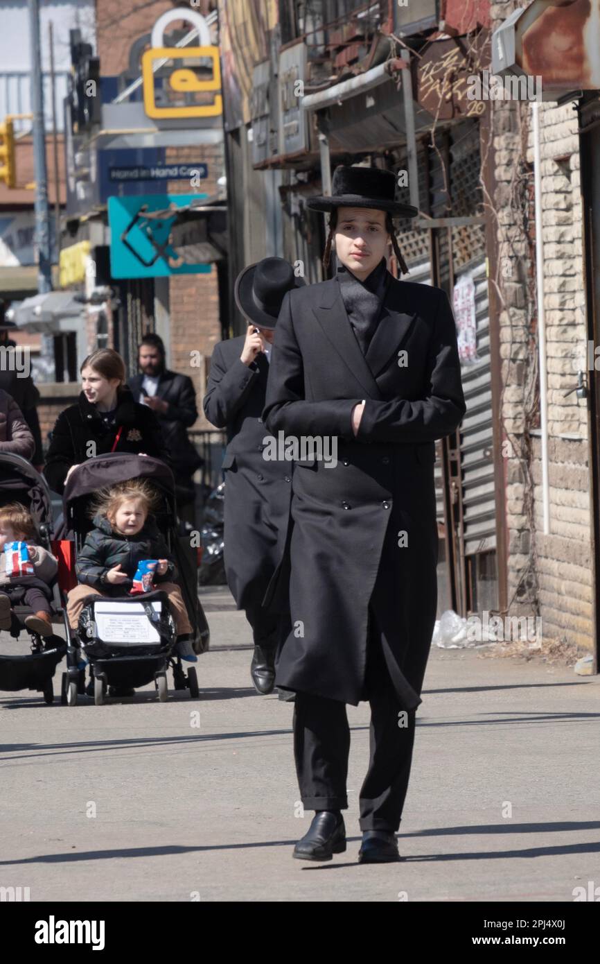A Hasidic jewish man in a long coat walks on Lee Avenue on a cold ...