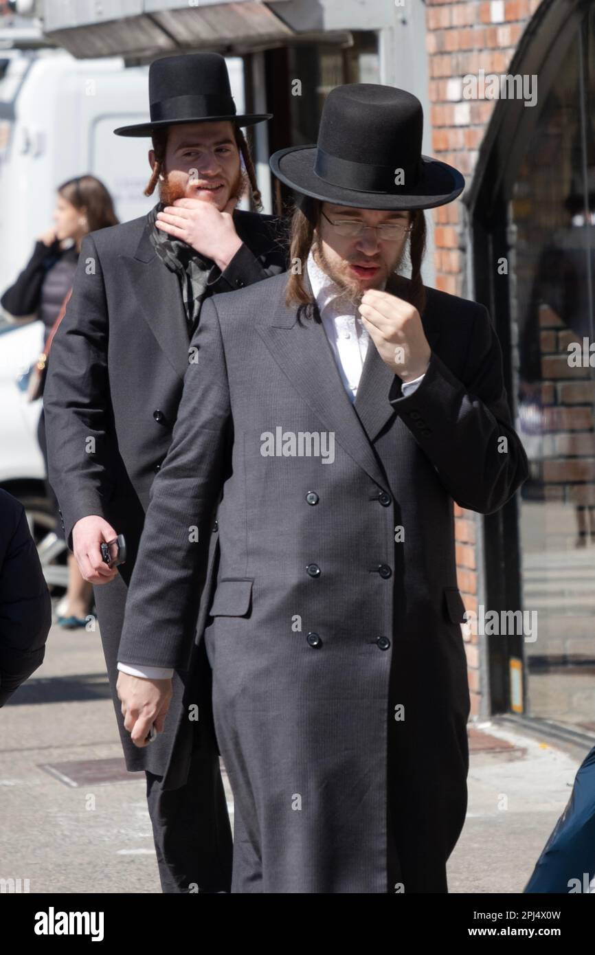 Two orthodox Jewish men with peyot walk in Williamsburg while stoking ...