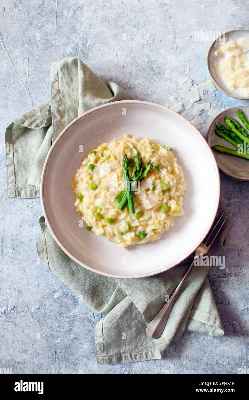 Italian risotto with asparagus and parmesan cheese on table. Top view ...