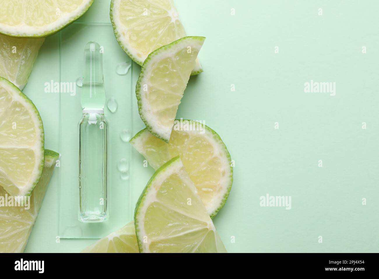 Pharmaceutical ampoule with medication and lime slices on turquoise ...