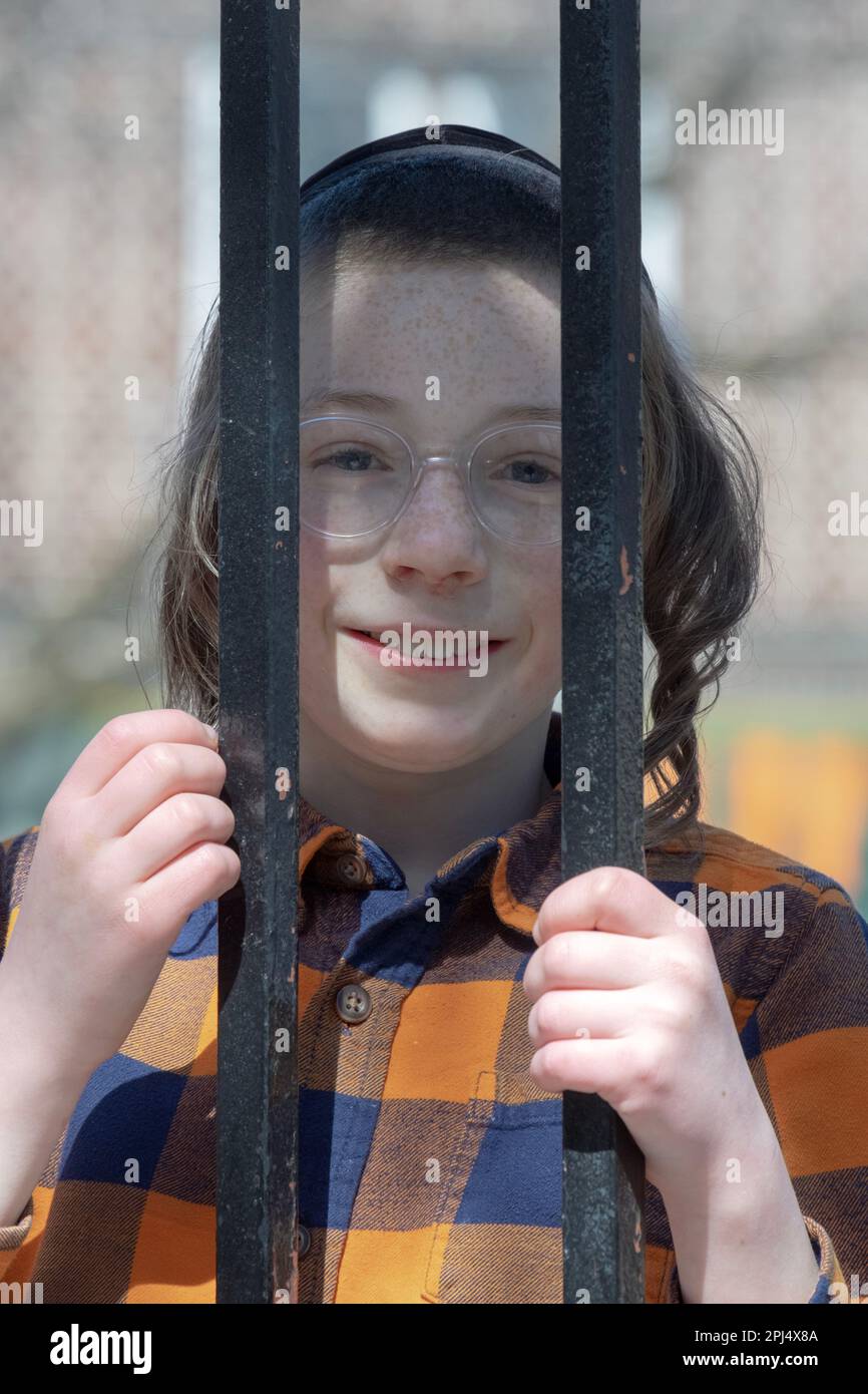 Posed photo of a Hasidic Jewish student in a park smiling between 2 ...