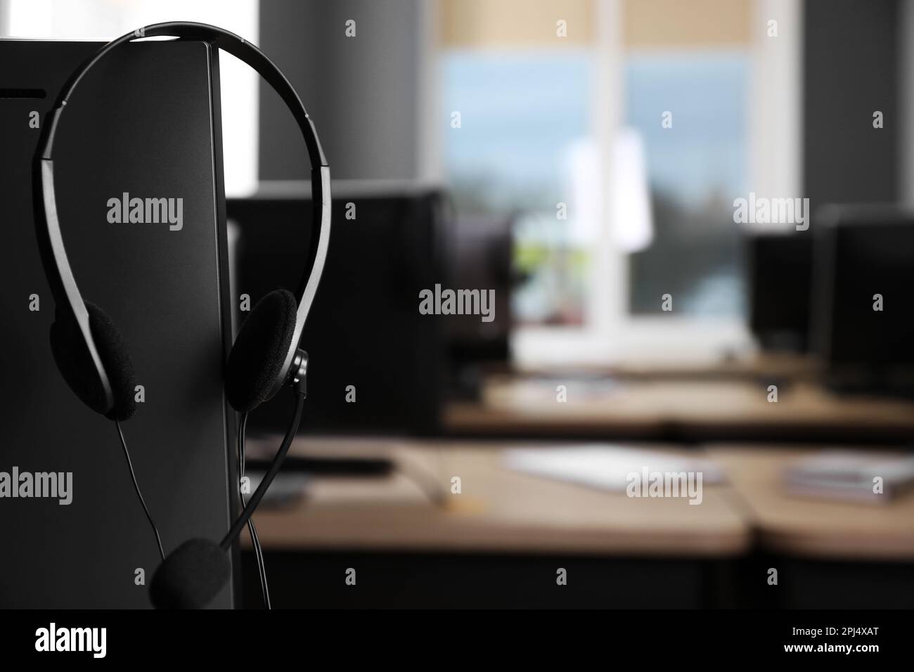 Modern computer with headset in office. Hotline service Stock Photo - Alamy