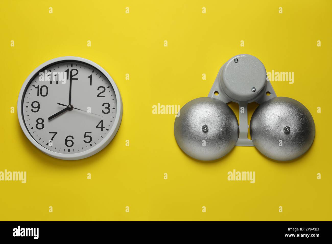 Modern electrical school bell and clock on yellow wall Stock Photo - Alamy