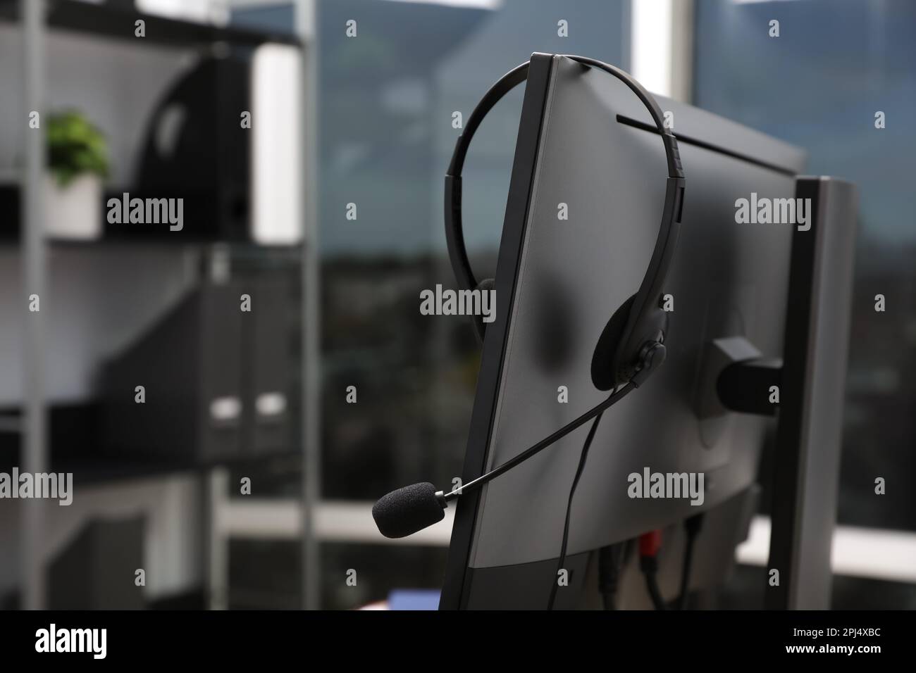 Modern computer with headset indoors. Hotline service Stock Photo - Alamy