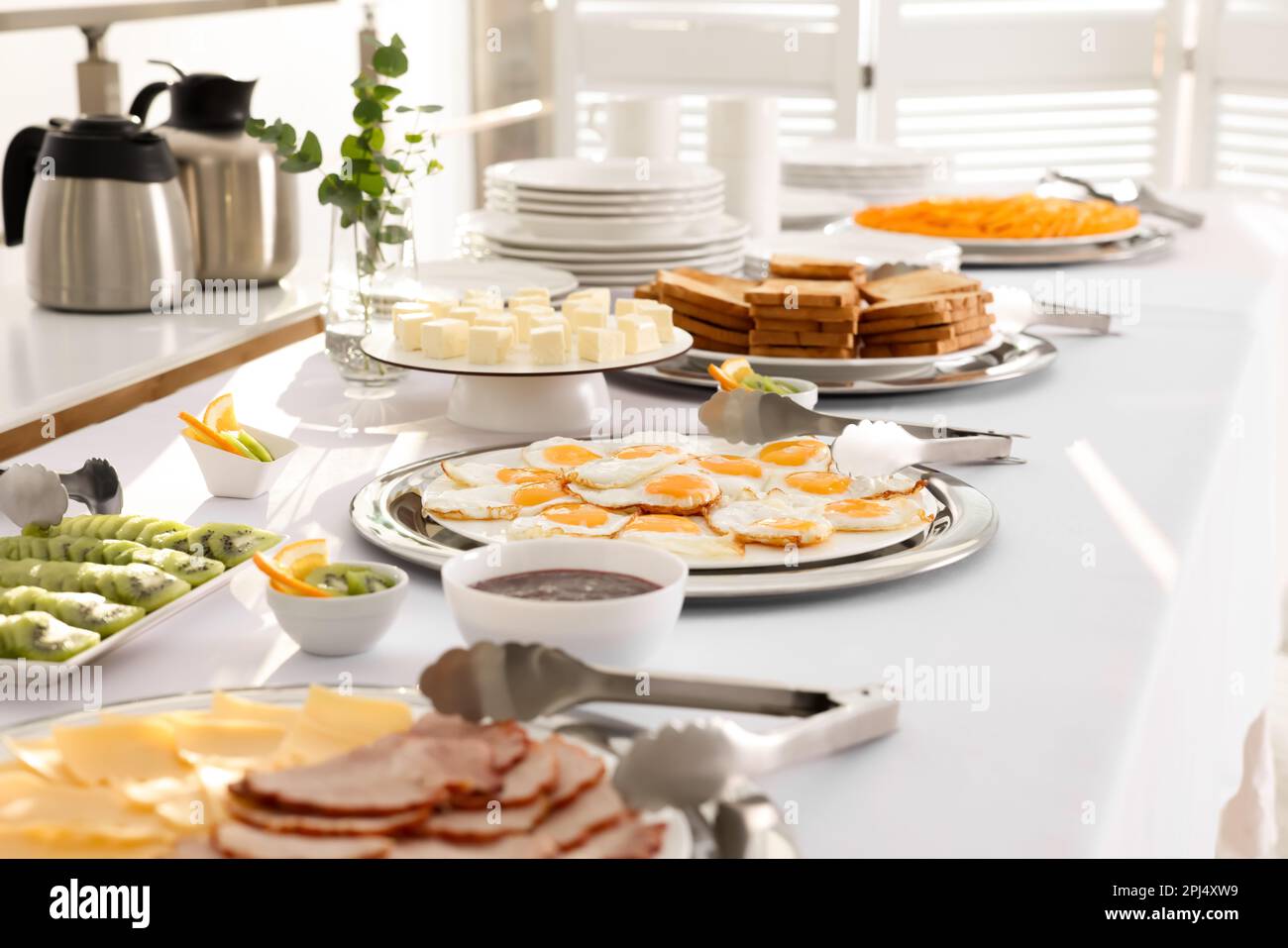 Different meals for breakfast on white table indoors. Buffet service ...